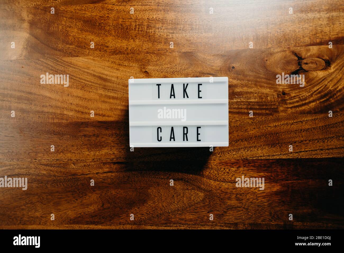 'Take care' text in light box on wooden background Stock Photo - Alamy