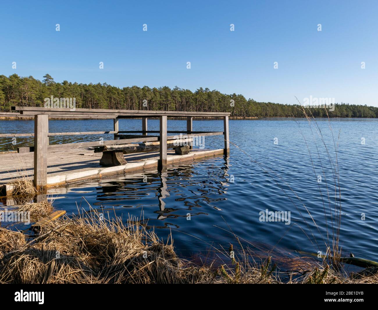 spring landscape with wooden viewing platform on the lake, snow ...