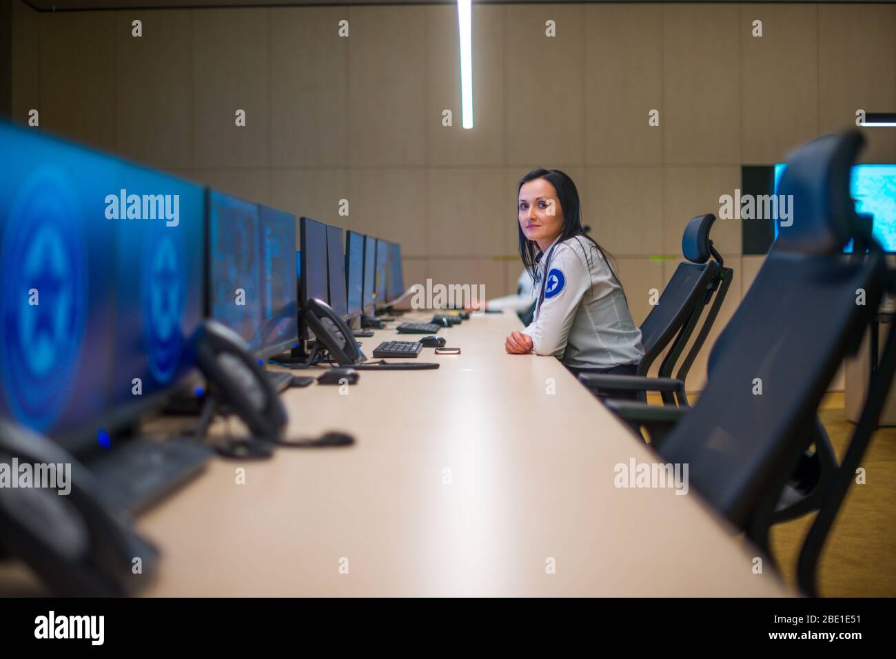 Female security guard sitting and monitoring modern CCTV cameras in ...