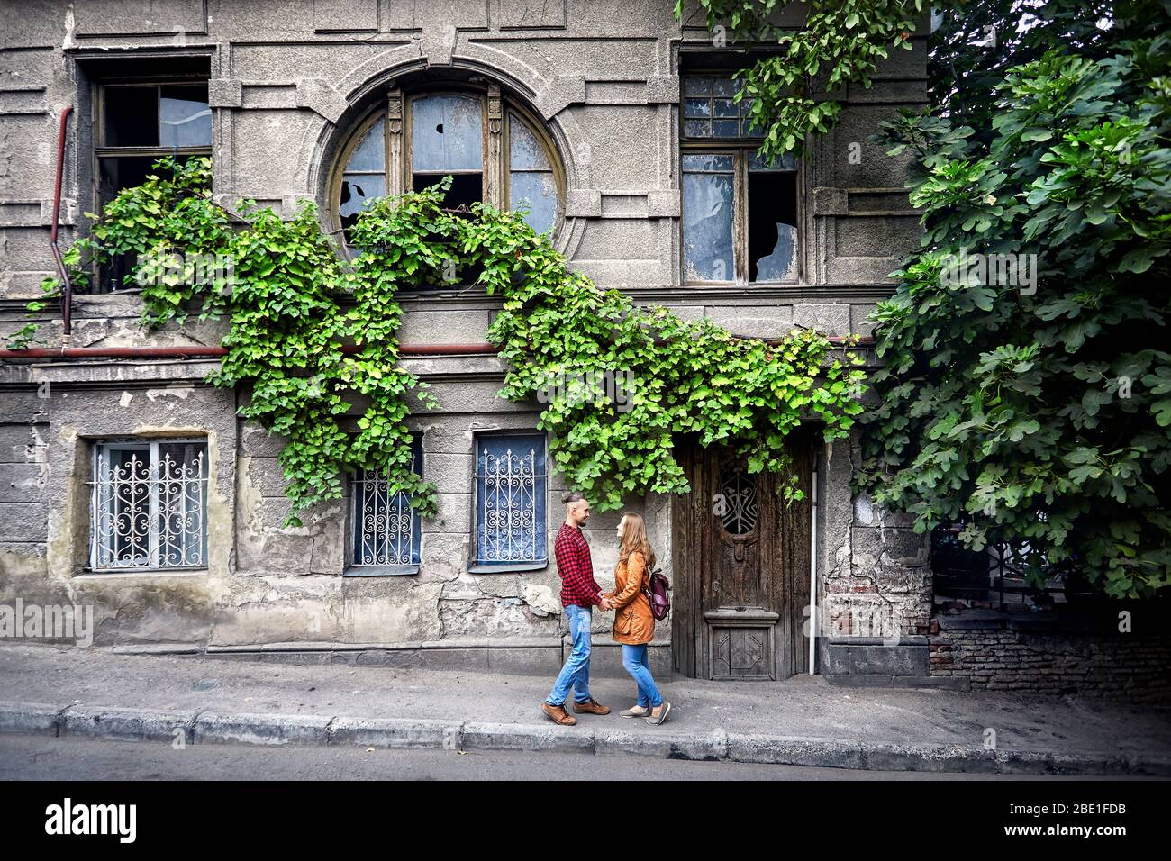 Happy couple of tourist near vintage house with round window at old ...