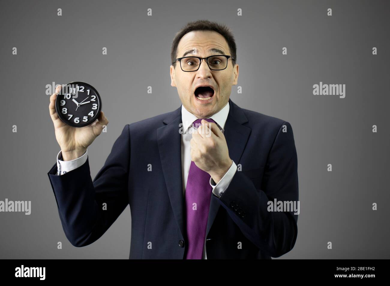 Stressed businessman with watch in hand. Man in panic, time management ...