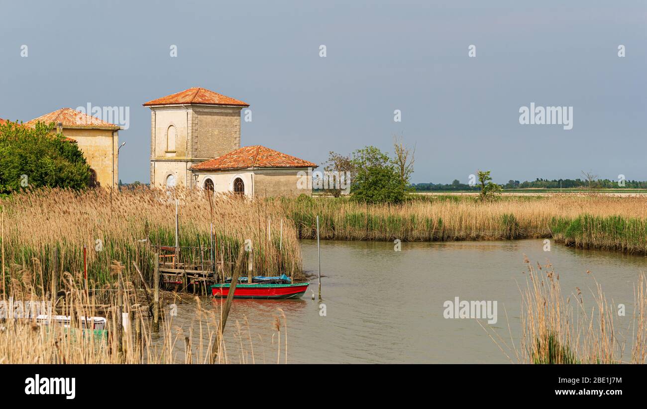 stone farm house with in front a cane ticket field on a water channel ...