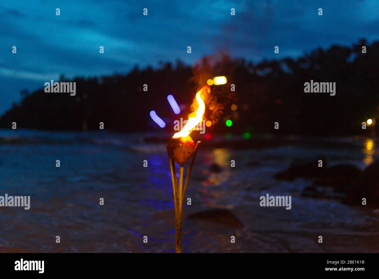 Burning torch on the sandy beach of the ocean Stock Photo - Alamy