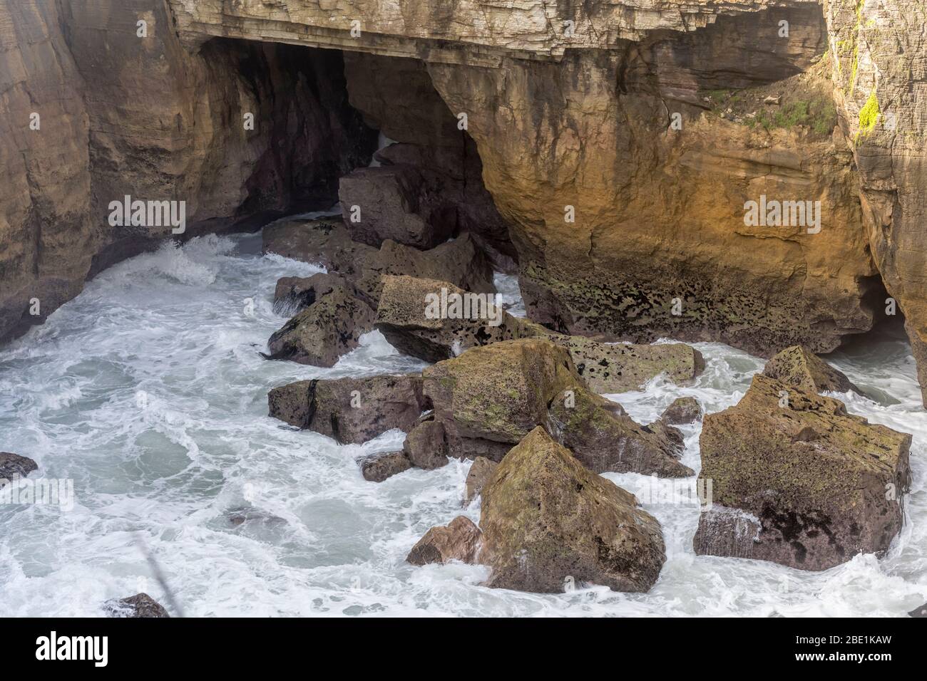landscape with rock cliffs and froth on water at Tasman sea shore ...