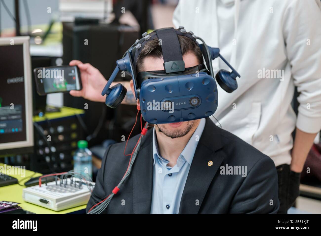 VR conference visitor tests virtual reality helmet Stock Photo - Alamy