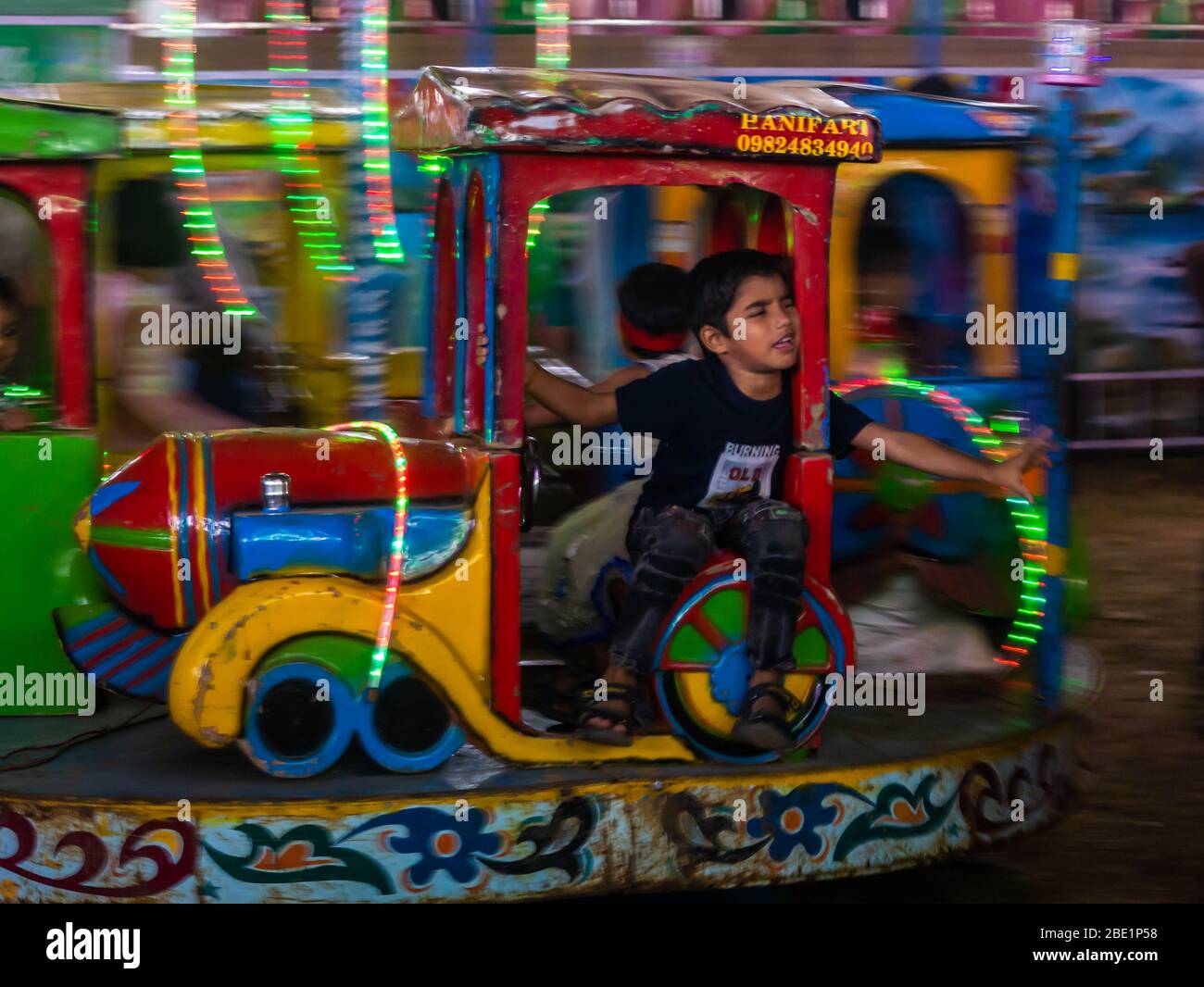 Mumbai, India - December 01, 2019: Indian kid enjoying carousel ride in ...