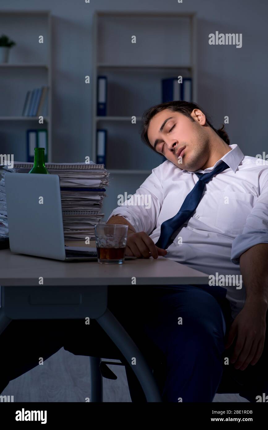 Alcohol addicted businessman working late Stock Photo - Alamy