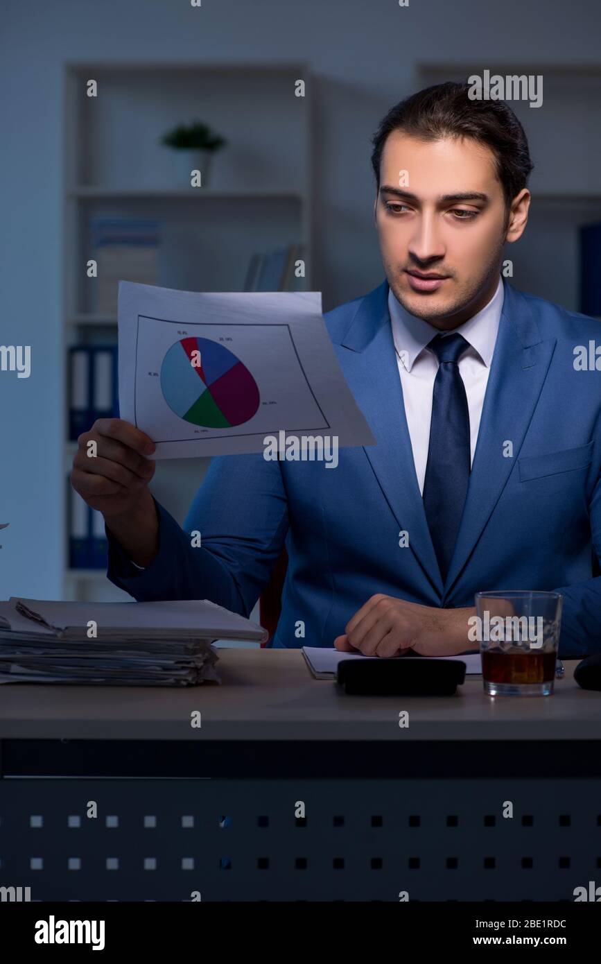 Alcohol addicted businessman working late Stock Photo - Alamy