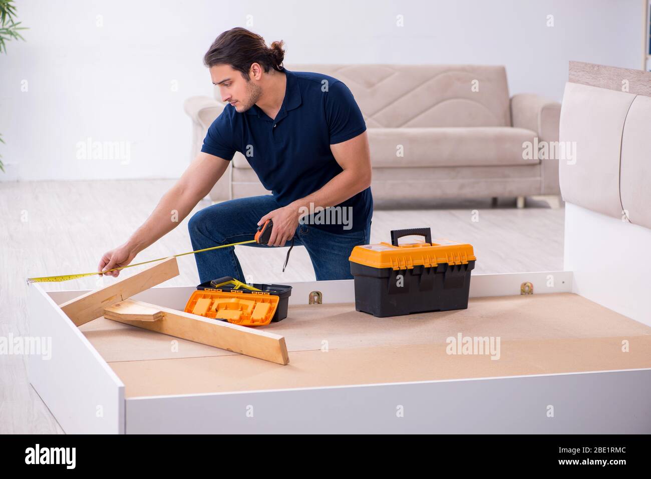 Young contractor installing furniture at home Stock Photo - Alamy