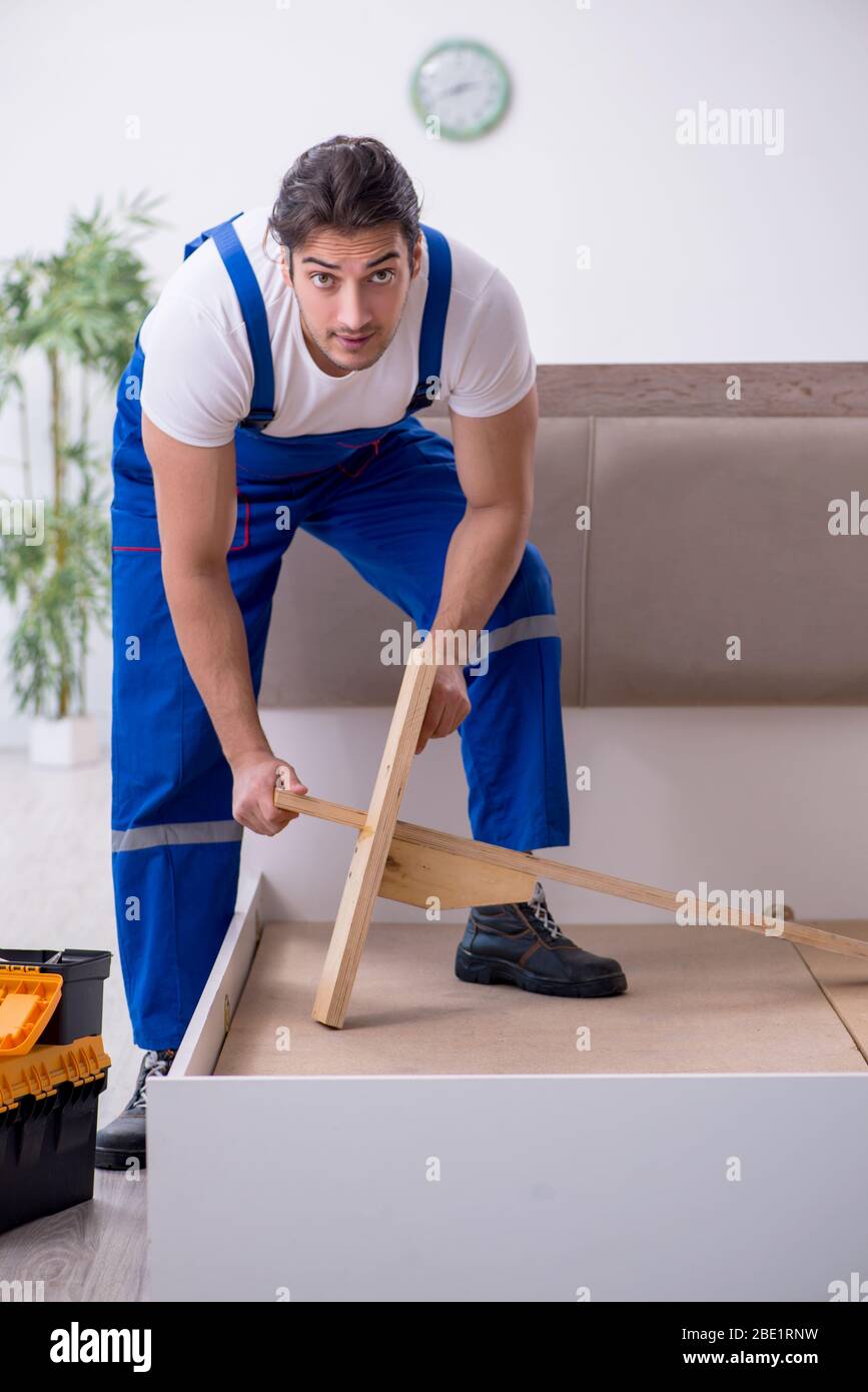 Young contractor installing furniture at home Stock Photo - Alamy
