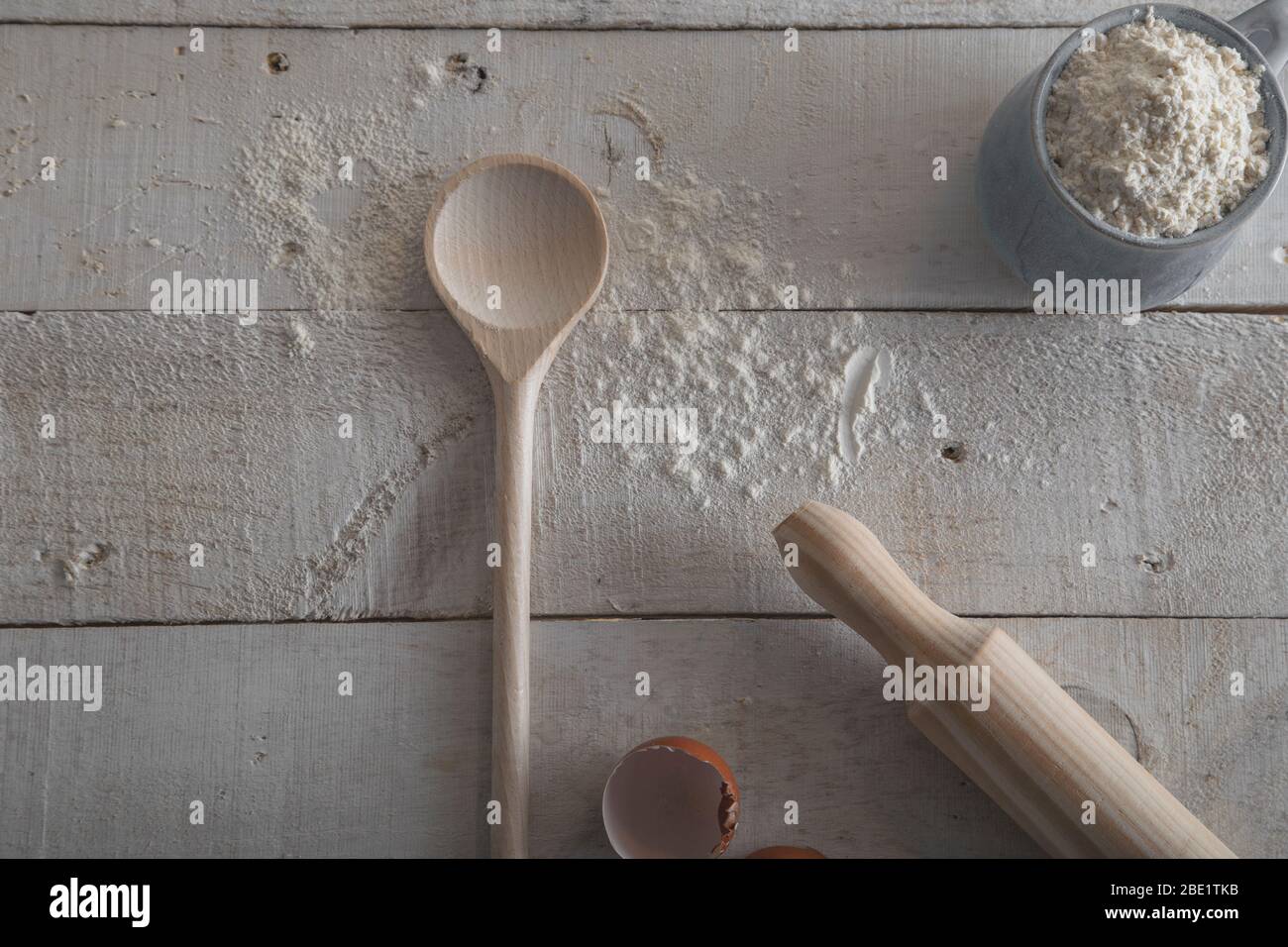 Rolling pin and wooden spoon for making dough on white wooden ...