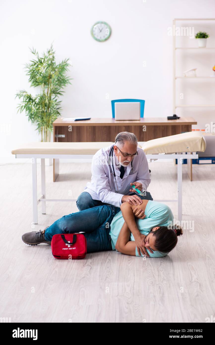 Experienced doctor and male patient in first aid concept Stock Photo ...
