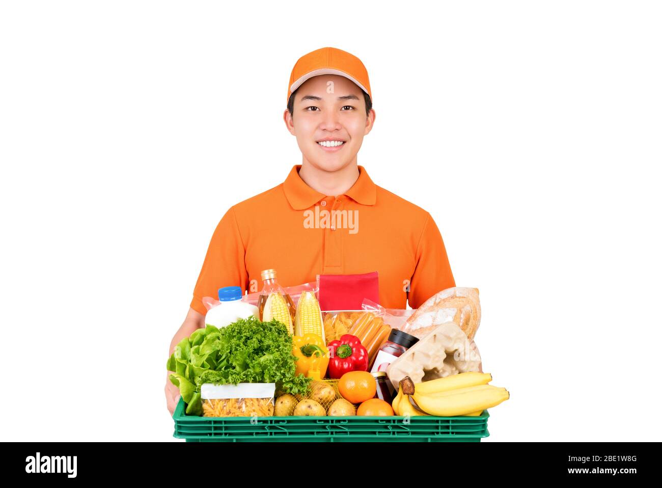 Smiling Asian delivery man in orange uniform holding grocery basket ...
