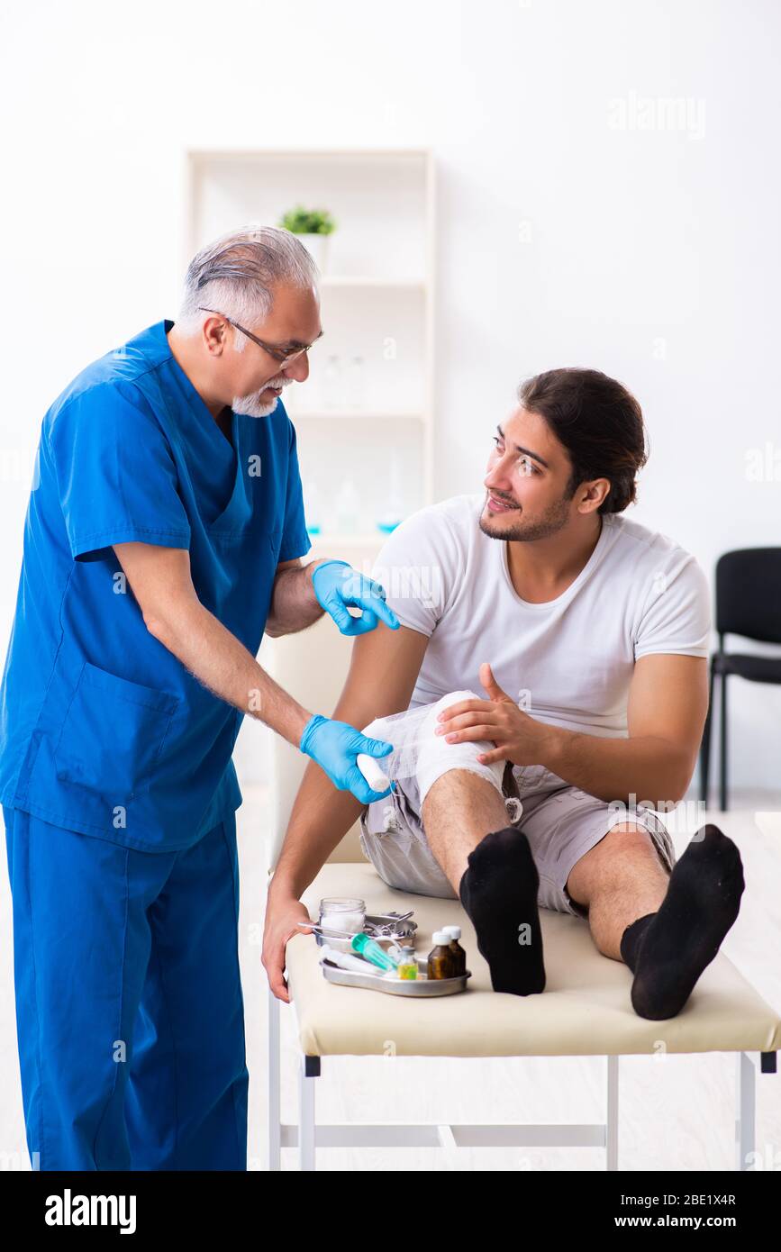 Leg injured man visiting doctor in first aid concept Stock Photo - Alamy