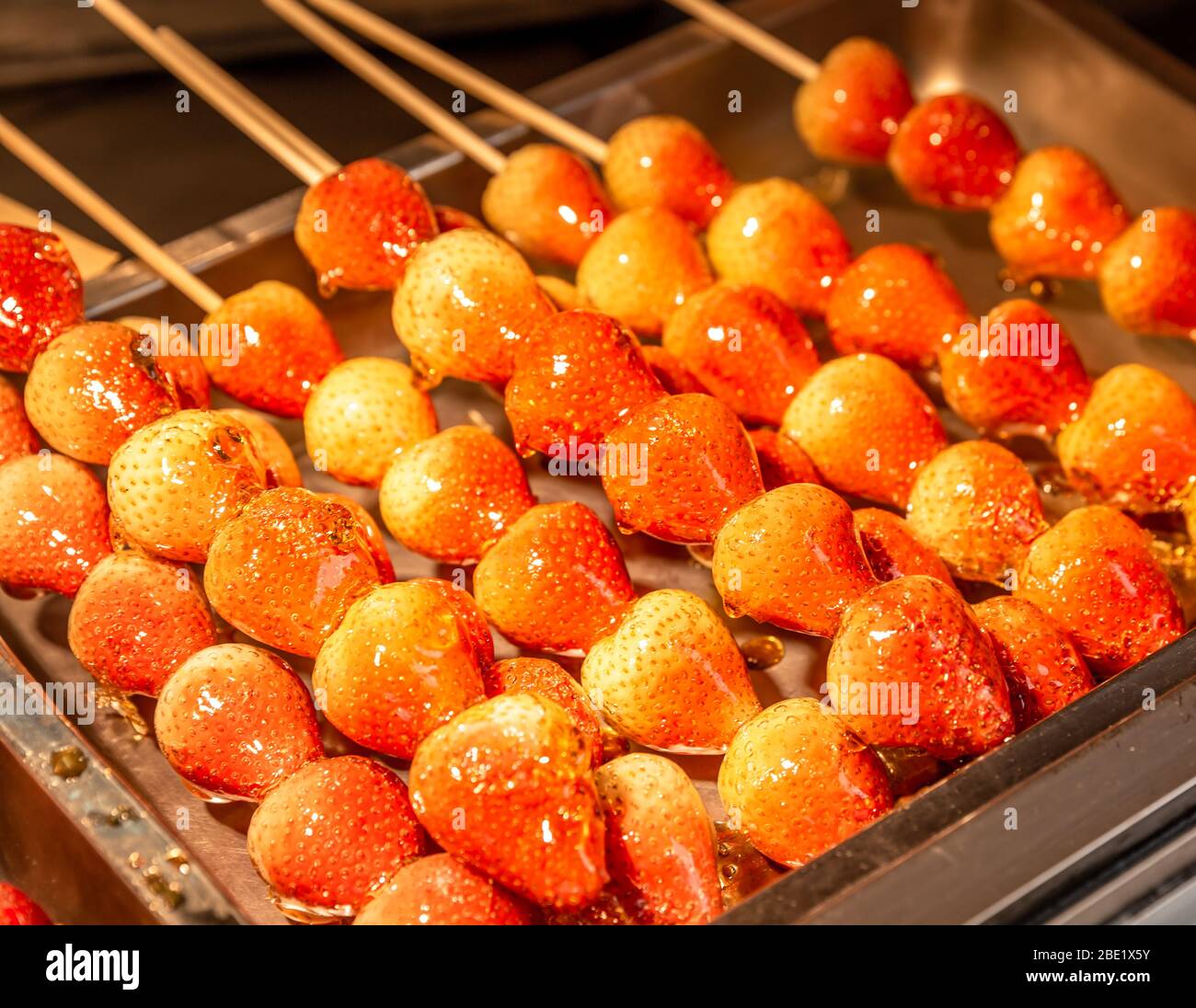 Strawberry coated with sugar on a stick at street food market Stock ...