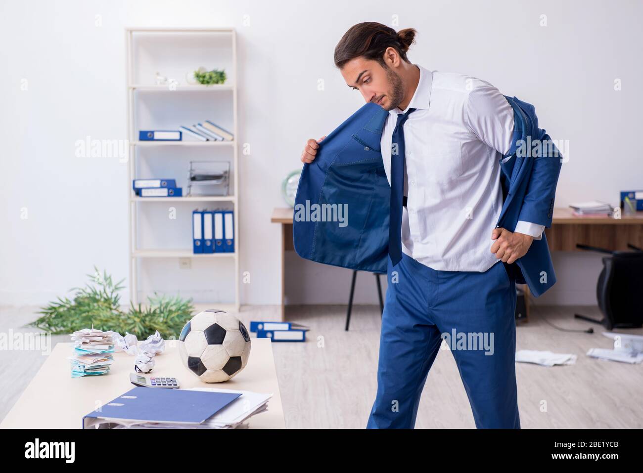 Young employee playing football in the office Stock Photo - Alamy