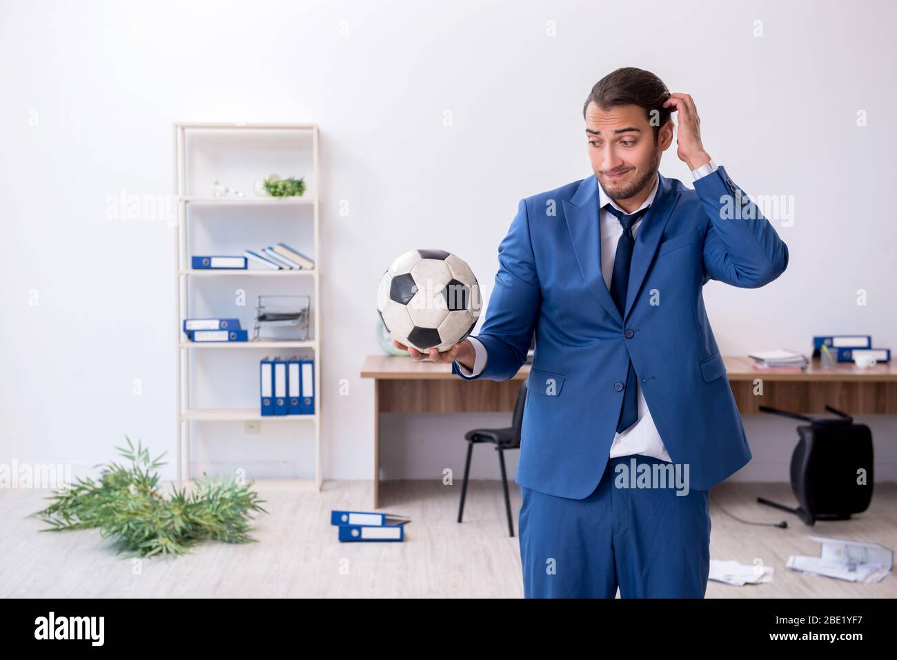 Young employee playing football in the office Stock Photo - Alamy