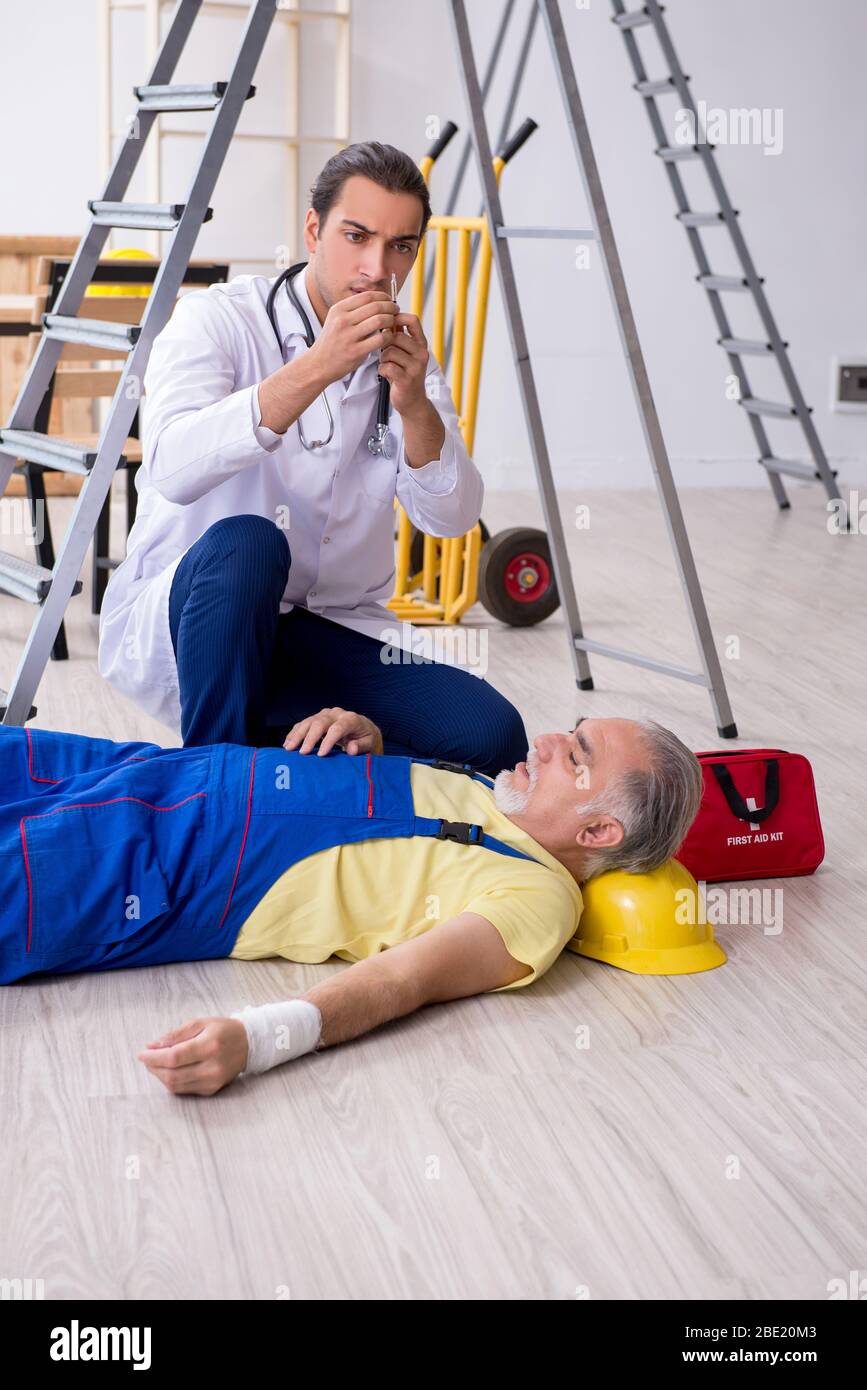 Young doctor and old contractor in first aid concept Stock Photo - Alamy