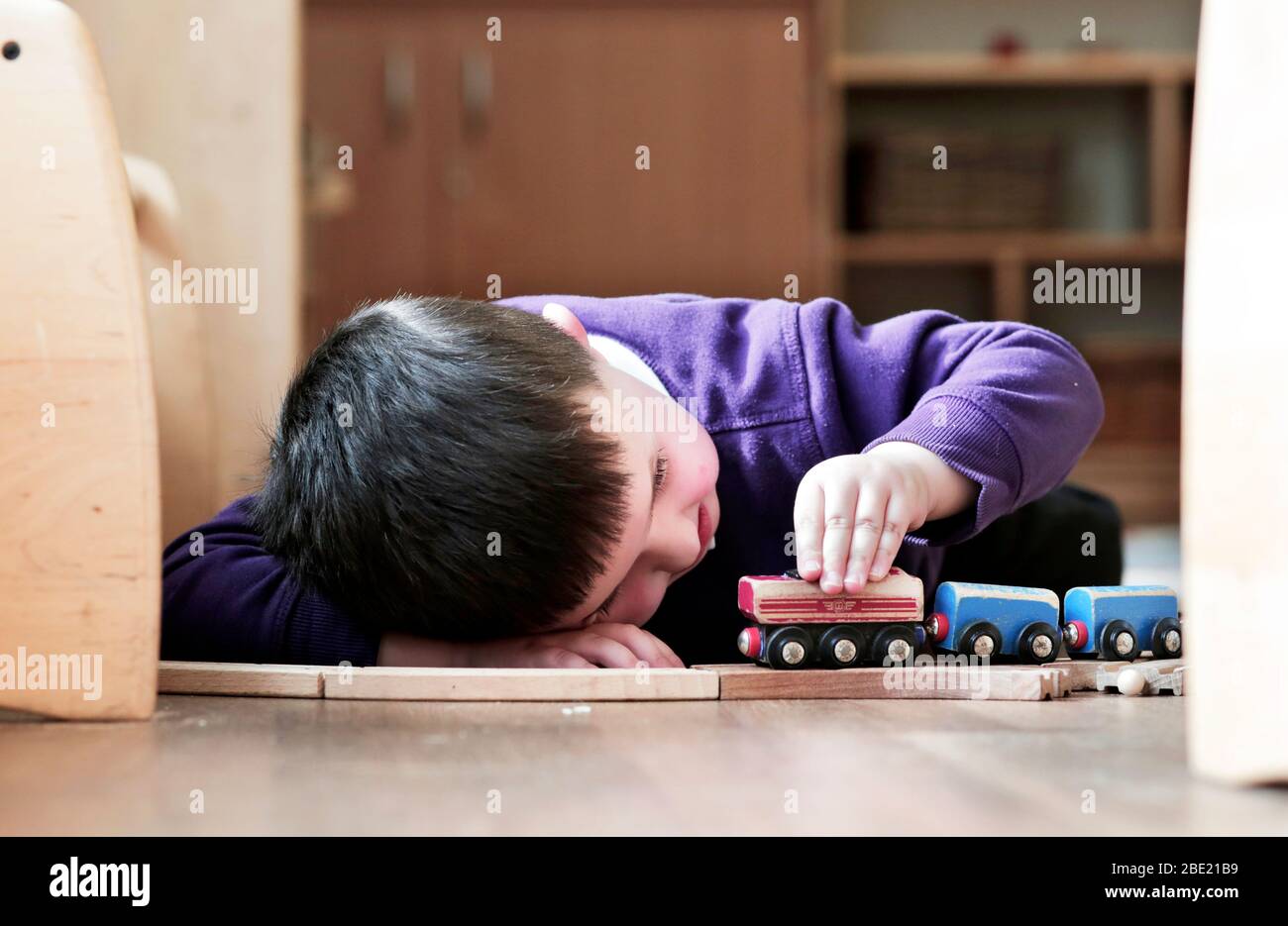 Child lying down playing with toy train hi-res stock photography and ...