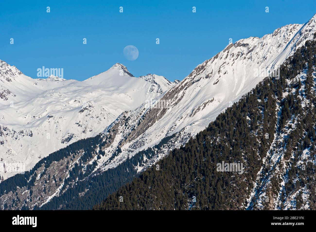 Panoramic view down snow covered valley in alpine mountain range with ...