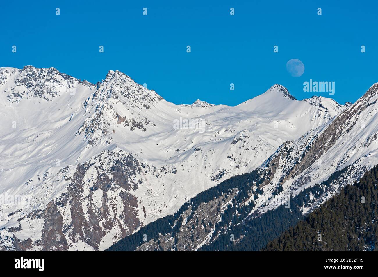 Panoramic view down snow covered valley in alpine mountain range with ...