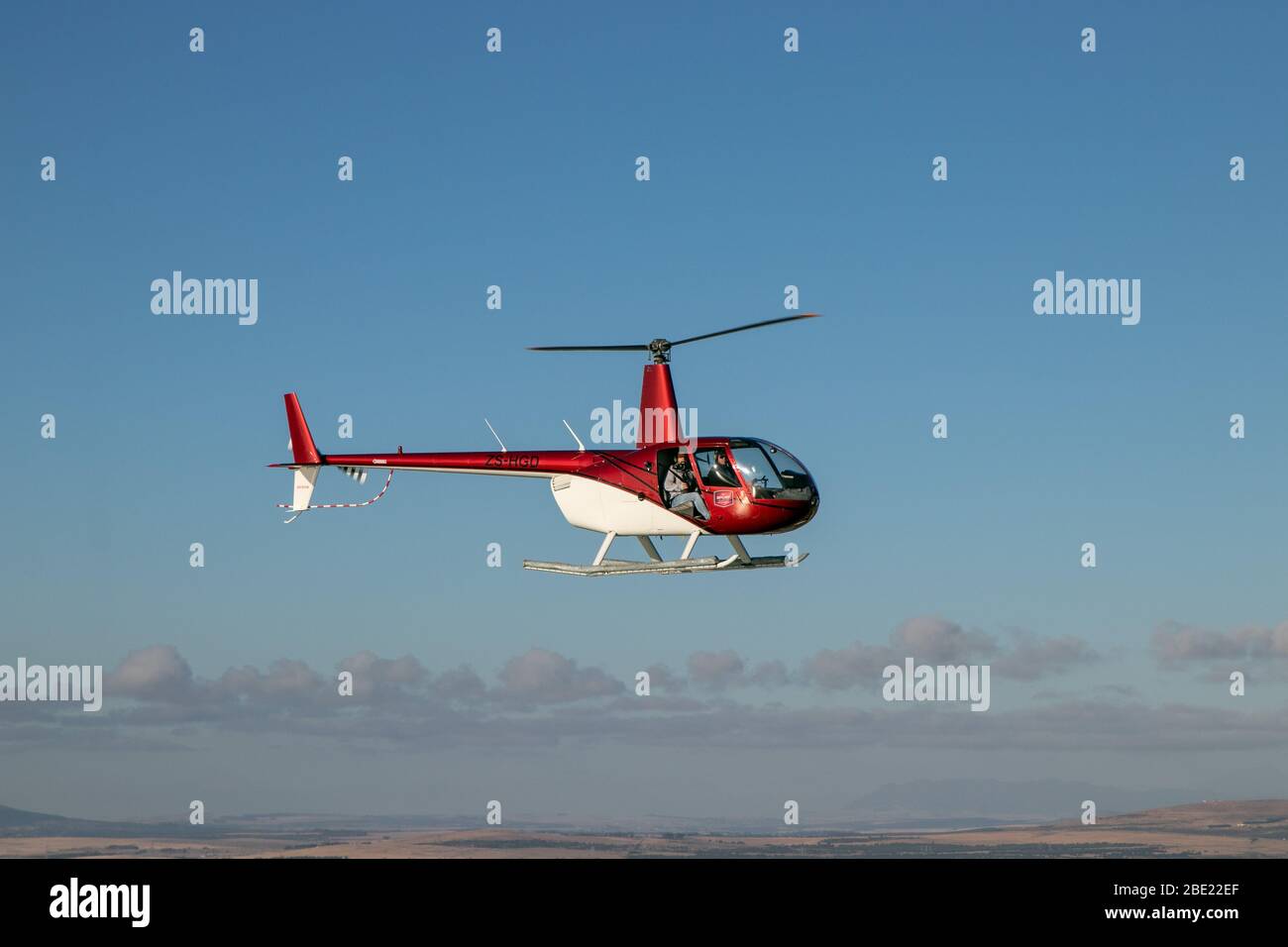 CAPE TOWN, SOUTH AFRICA. April 2020. An R44 helicopter in red and white ...