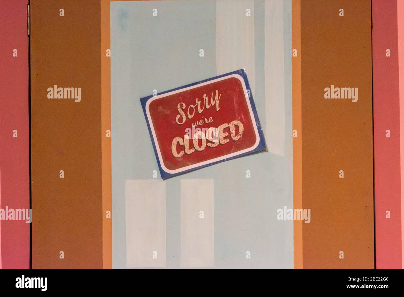 Sorry we're closed sign on painted pastel door. Shut down, closed ...