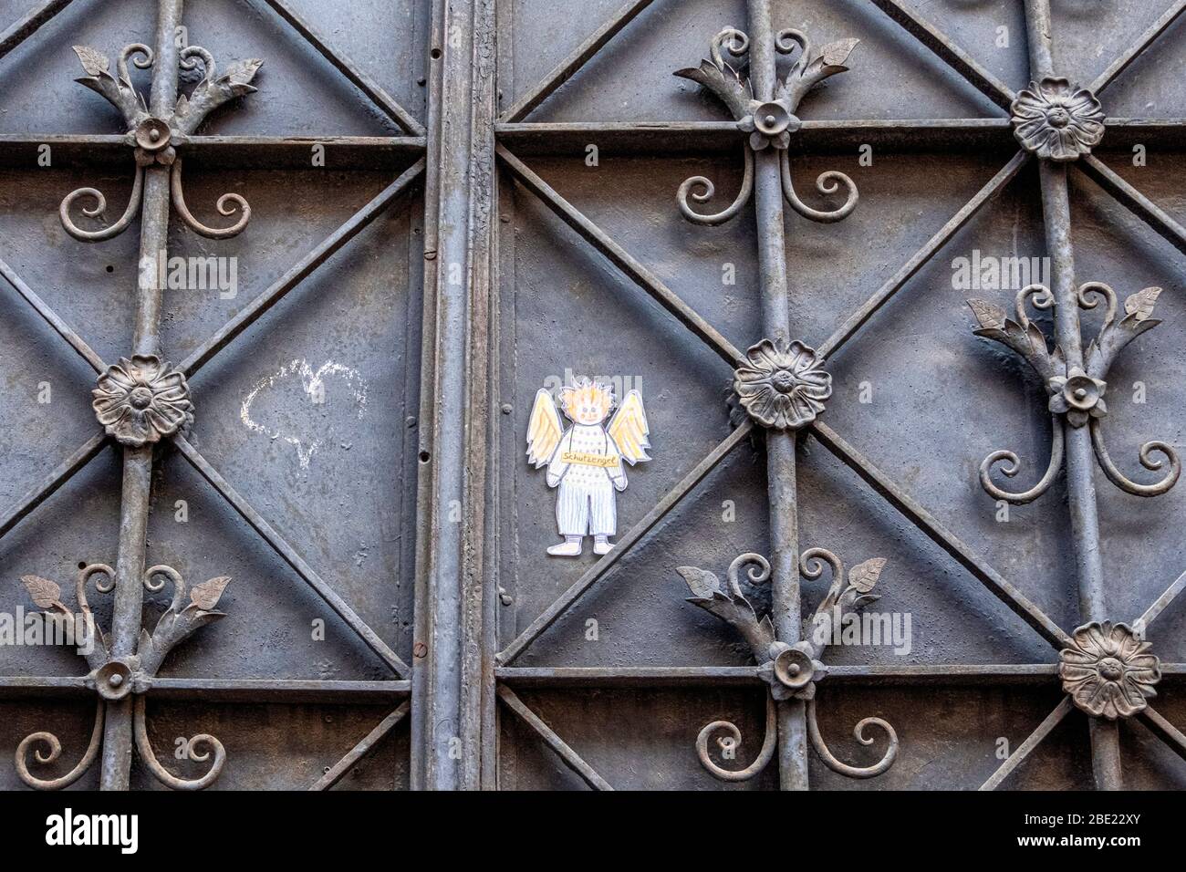 Small paper angel and chalk heart on decorative wrought iron metal gate ...
