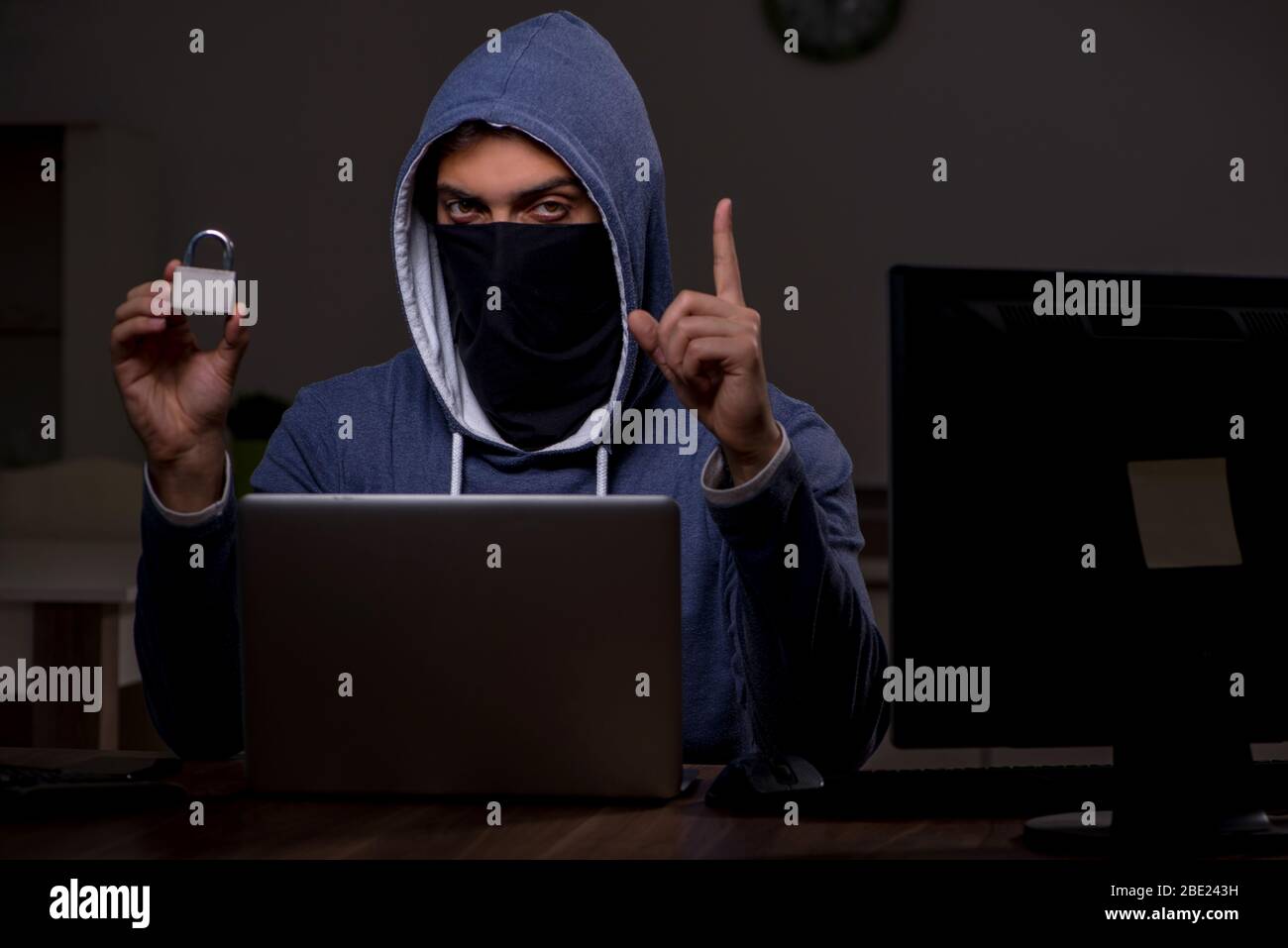 Male hacker hacking security firewall late in the office Stock Photo ...