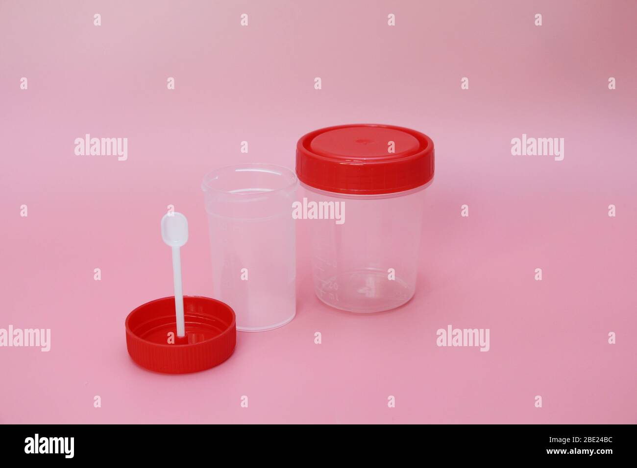 Jars for analysis on a pink background. Containers for feces and urine ...