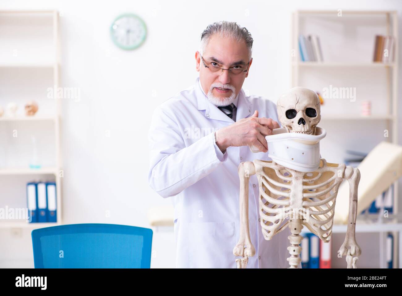 The aged male doctor with skeleton Stock Photo - Alamy