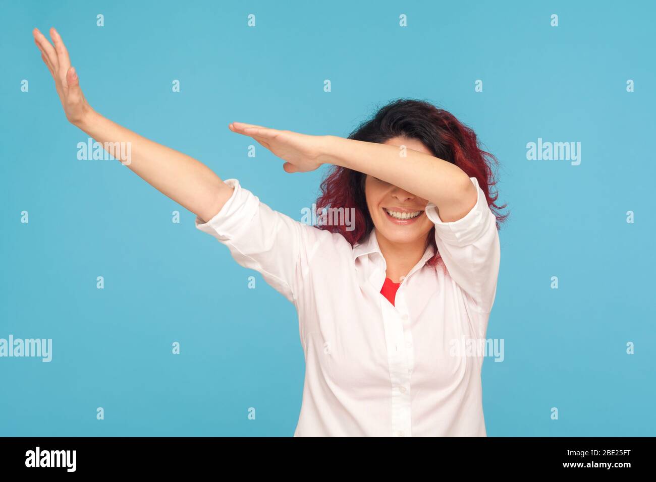 Happy cheerful woman in white shirt showing dab dance move, celebrating ...