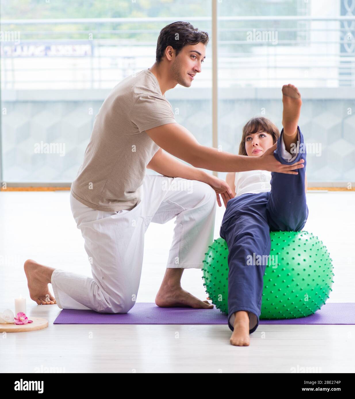 The personal coach helping woman in gym with stability ball Stock Photo ...