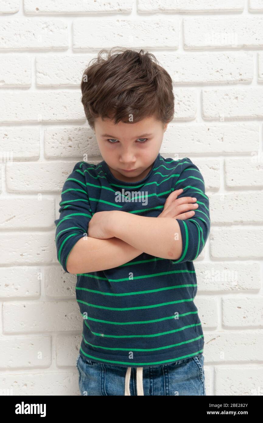 Angry frowning boy on brick wall background Stock Photo - Alamy