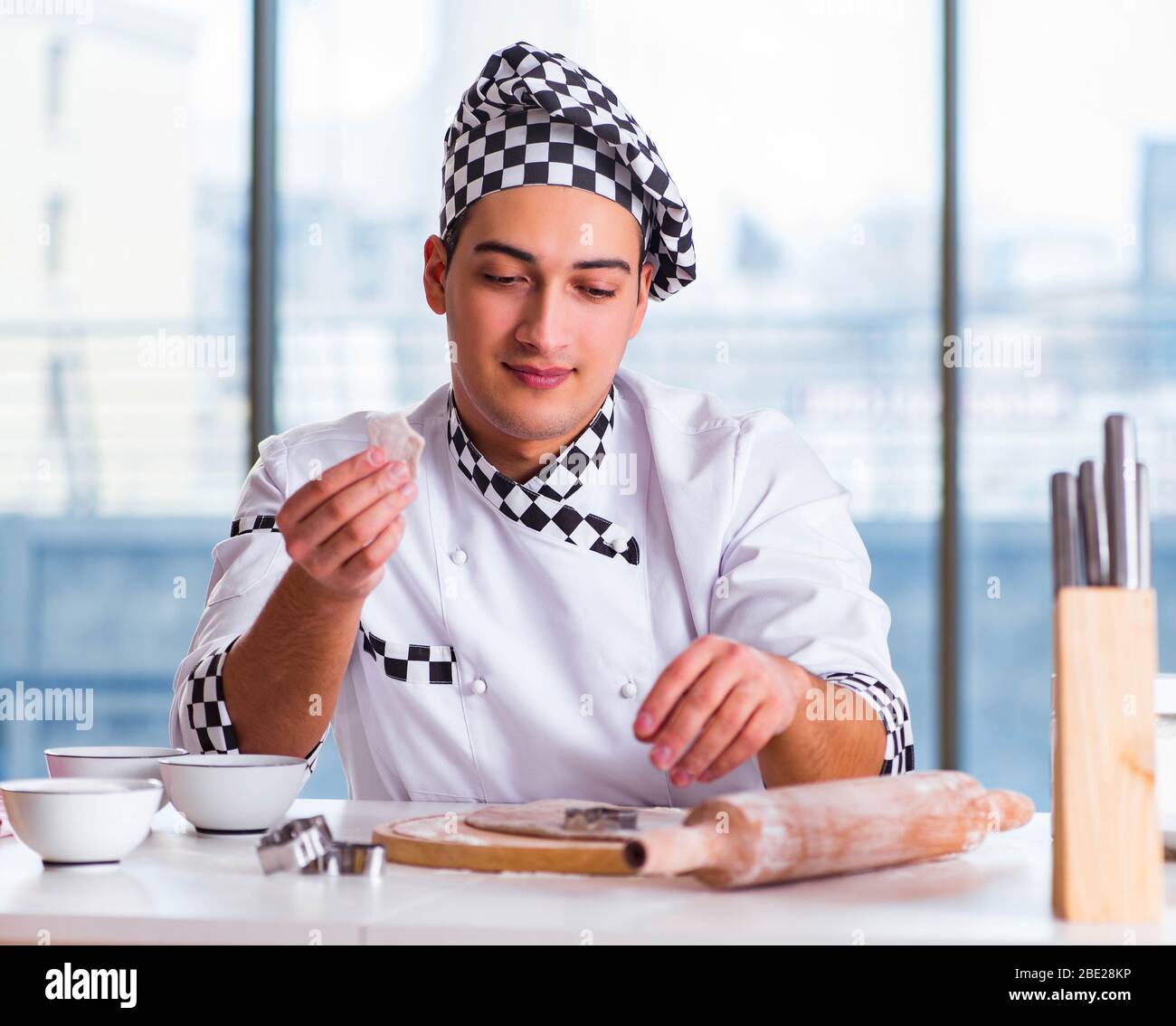 The young man cooking cookies in kitchen Stock Photo - Alamy