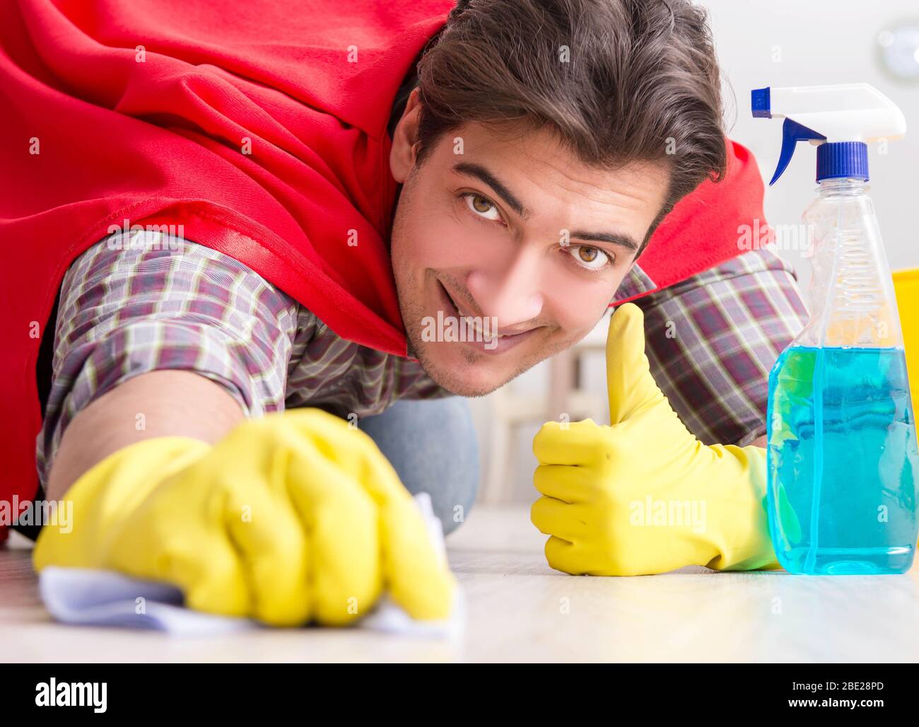 The super hero husband cleaning floor at home Stock Photo - Alamy