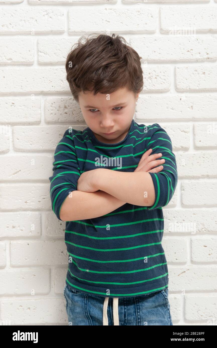 Angry frowning boy on brick wall background Stock Photo - Alamy
