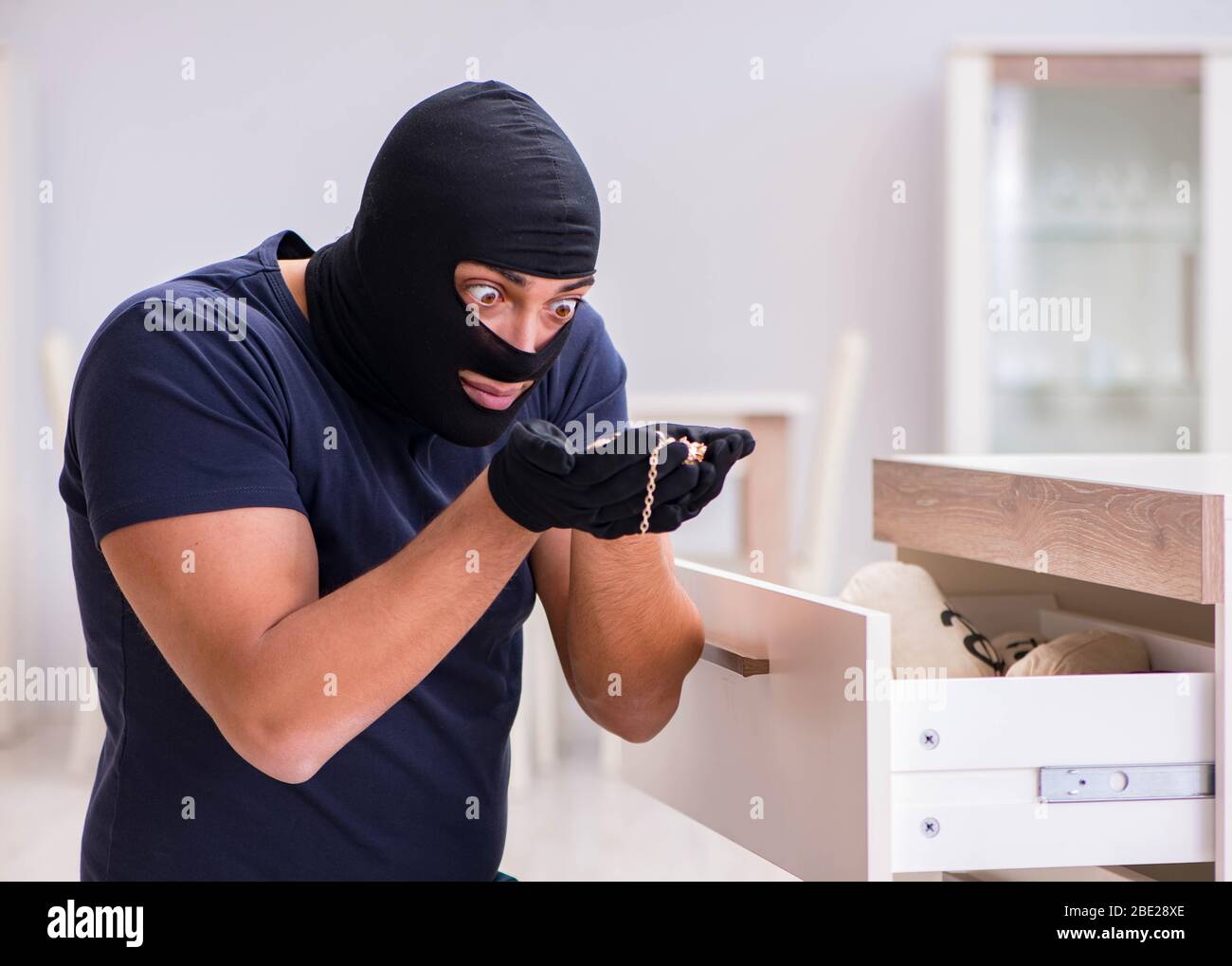 The robber wearing balaclava stealing valuable things Stock Photo - Alamy