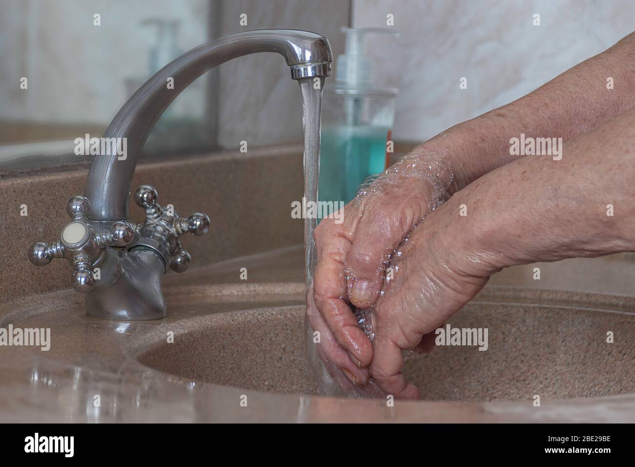 Elderly woman washing hands hi-res stock photography and images - Alamy