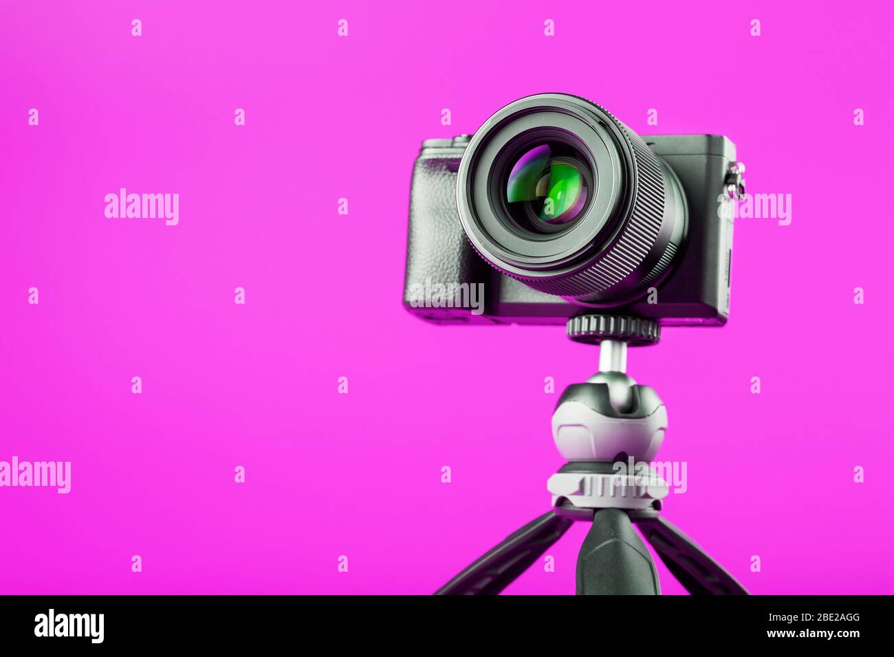 Professional camera on a tripod, on a pink background. Record videos ...