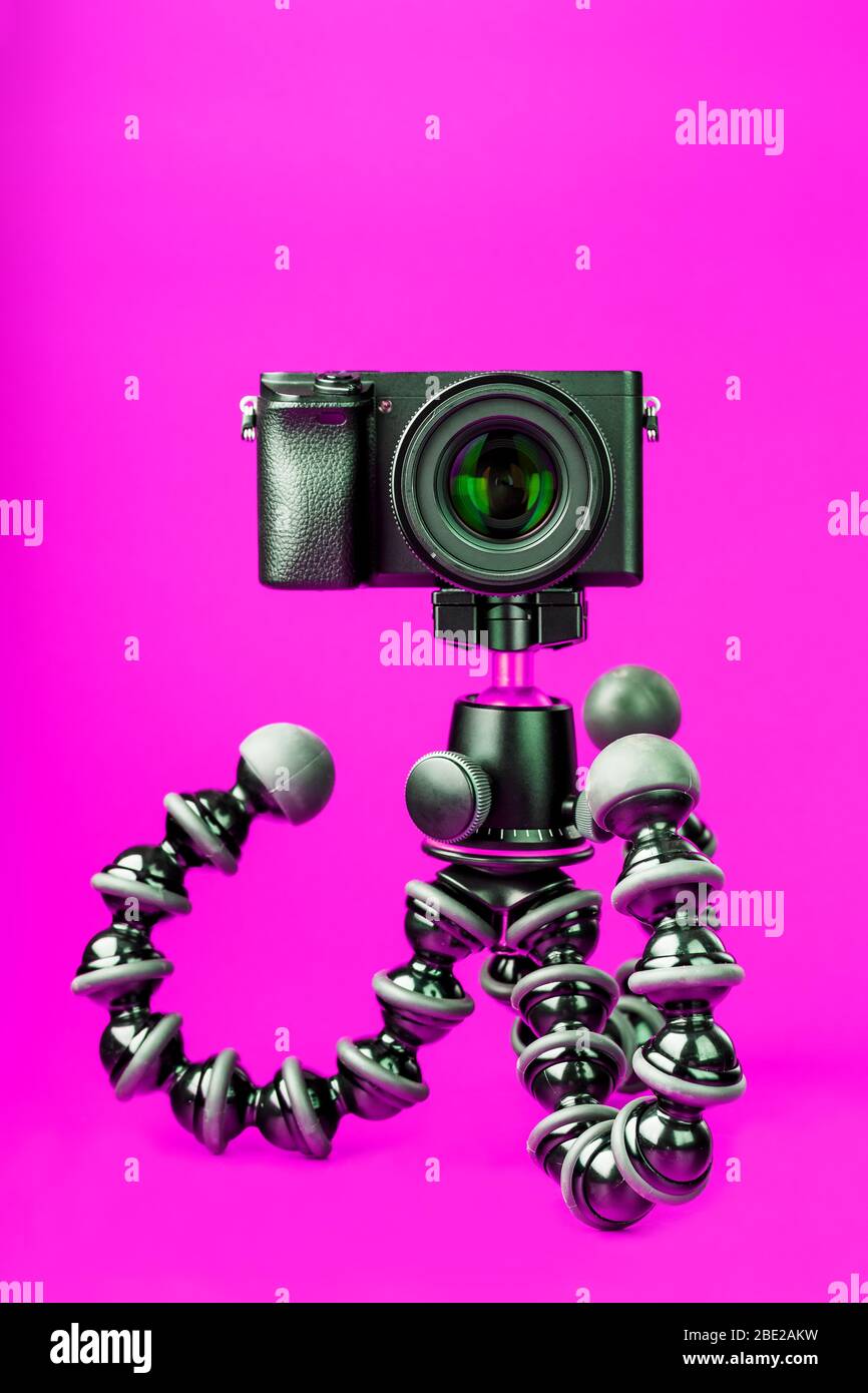 Professional camera on a tripod, on a pink background. Record videos ...