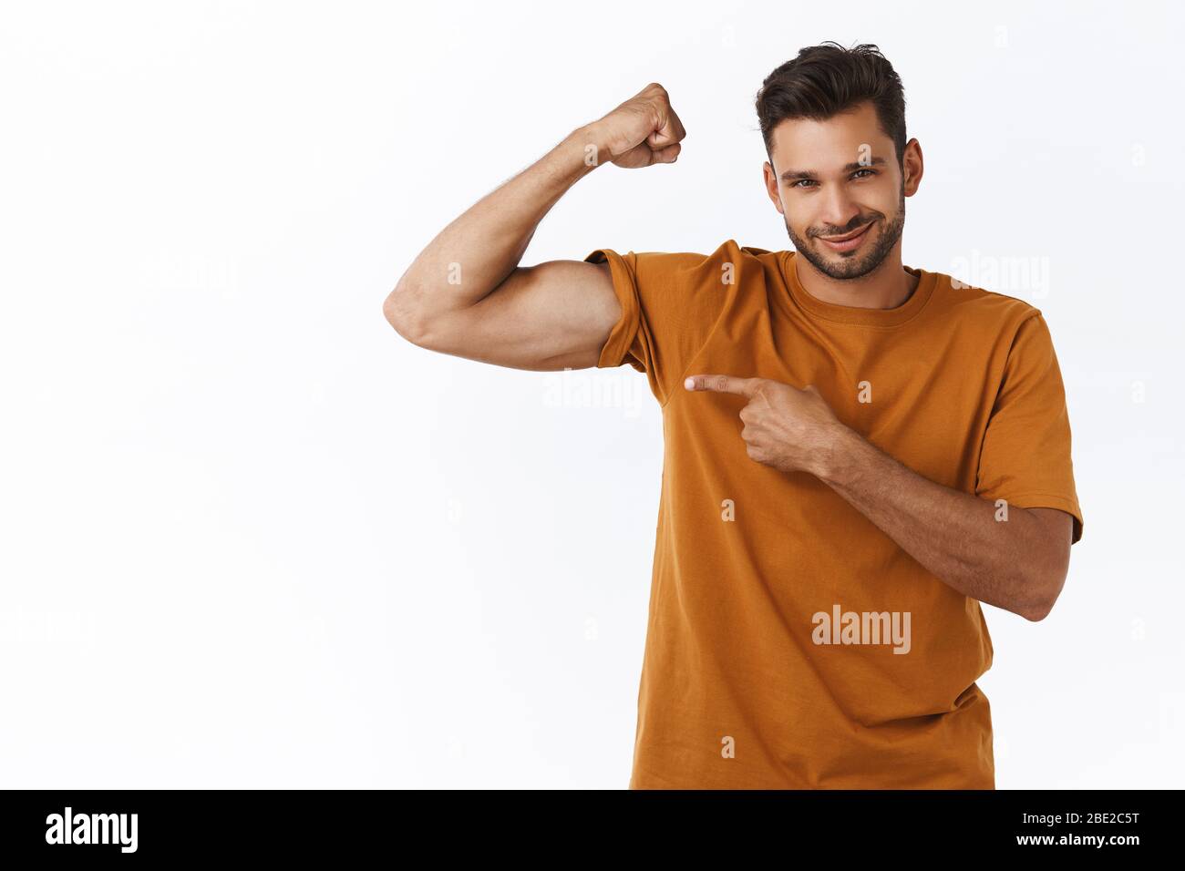Sassy confident smiling macho man with big muscles, proudly pointing ...