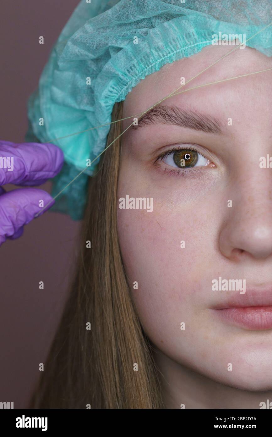 Close-up of female eye with thriding. Triding popular thread eyebrow ...