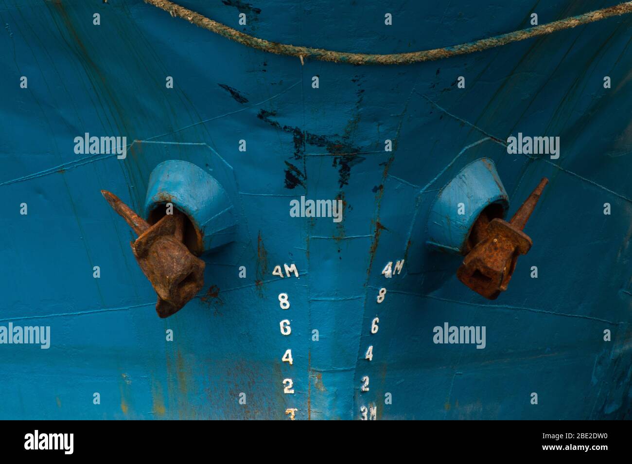 Close-up of two anchors at the bow of a blue commercial ship Stock ...