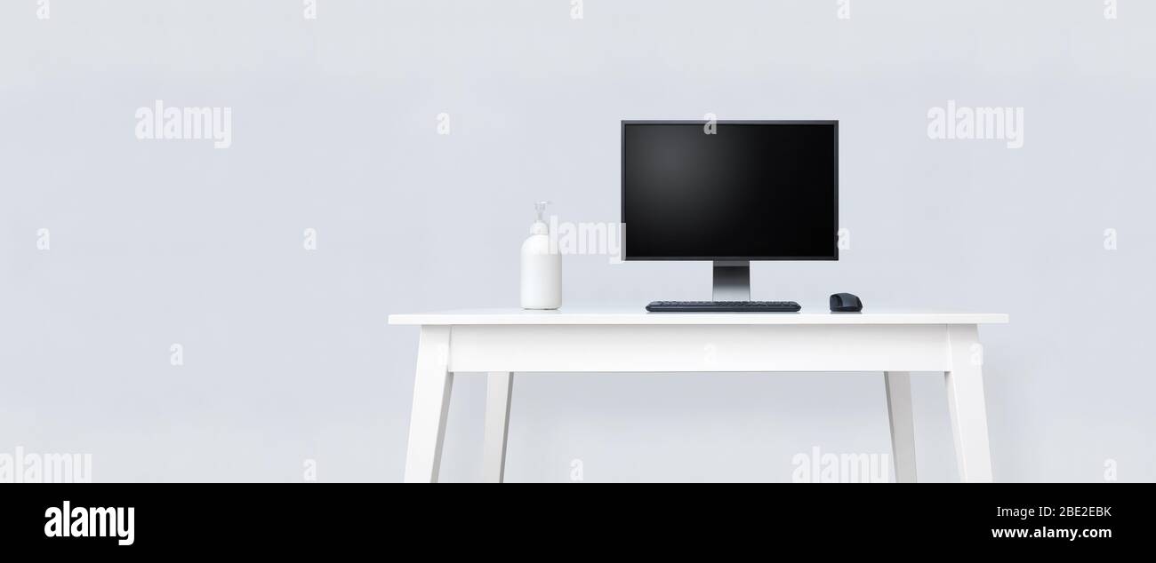 Clean white table with desktop computer and bottle with hand ...