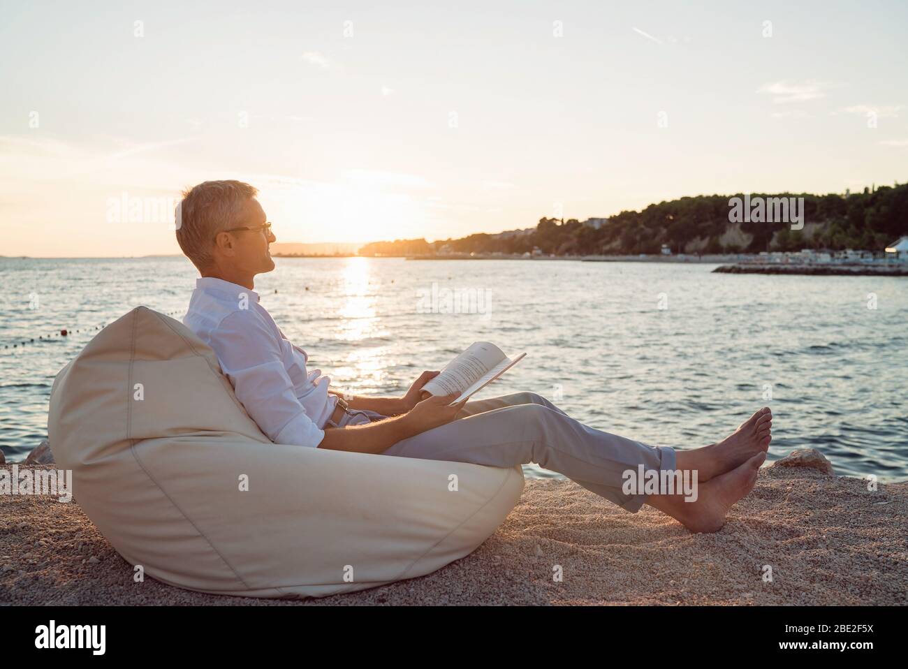Man lying on beach and reading book hi-res stock photography and images ...