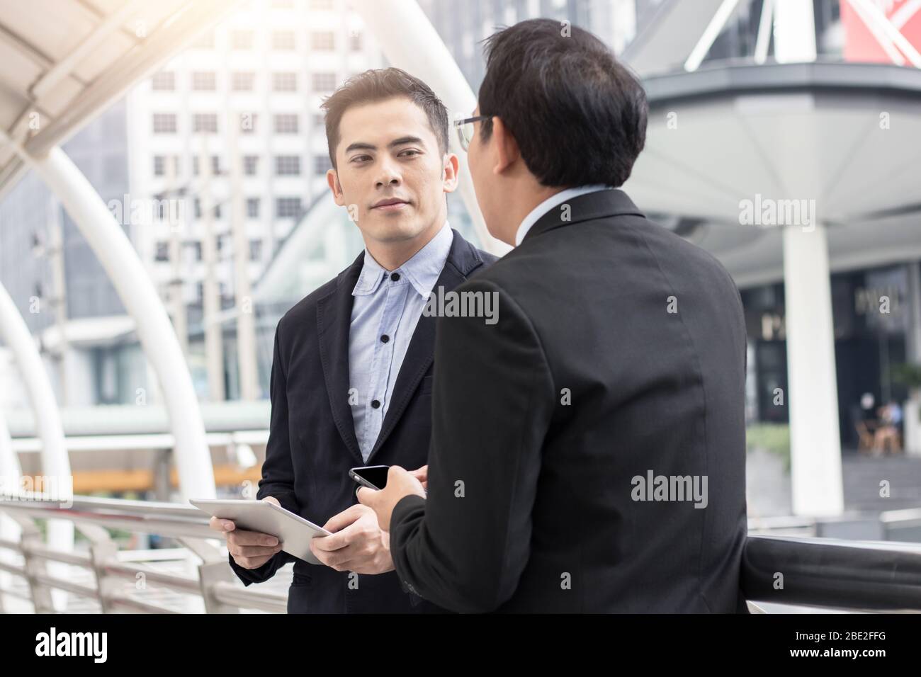 Happy partner business people stand talking and discussing in front of ...