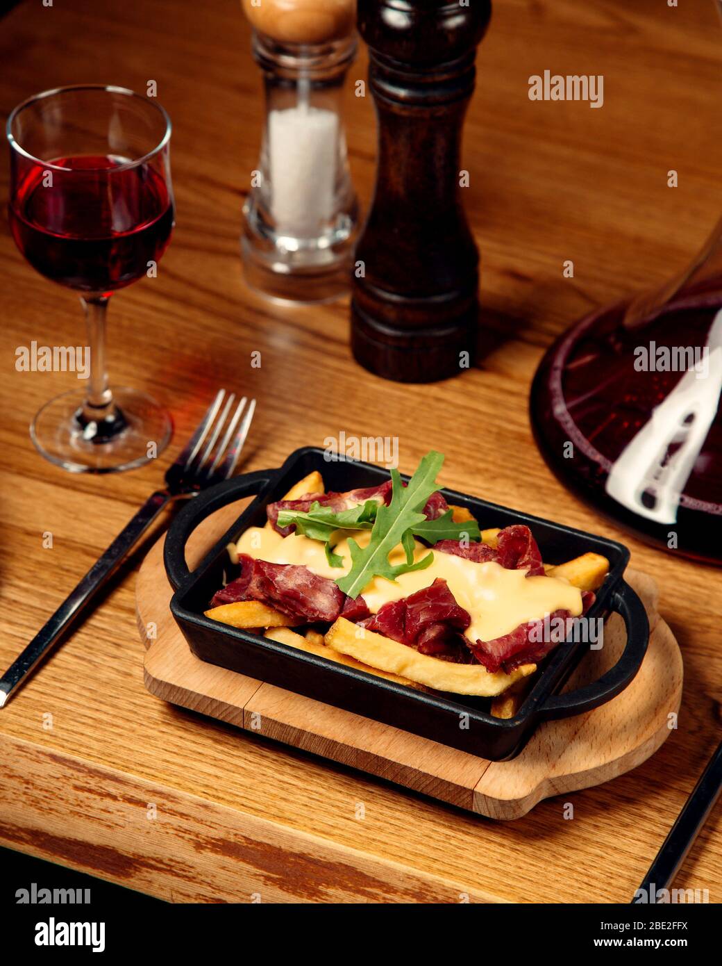 cured meat served with french fries and melted cheese Stock Photo - Alamy