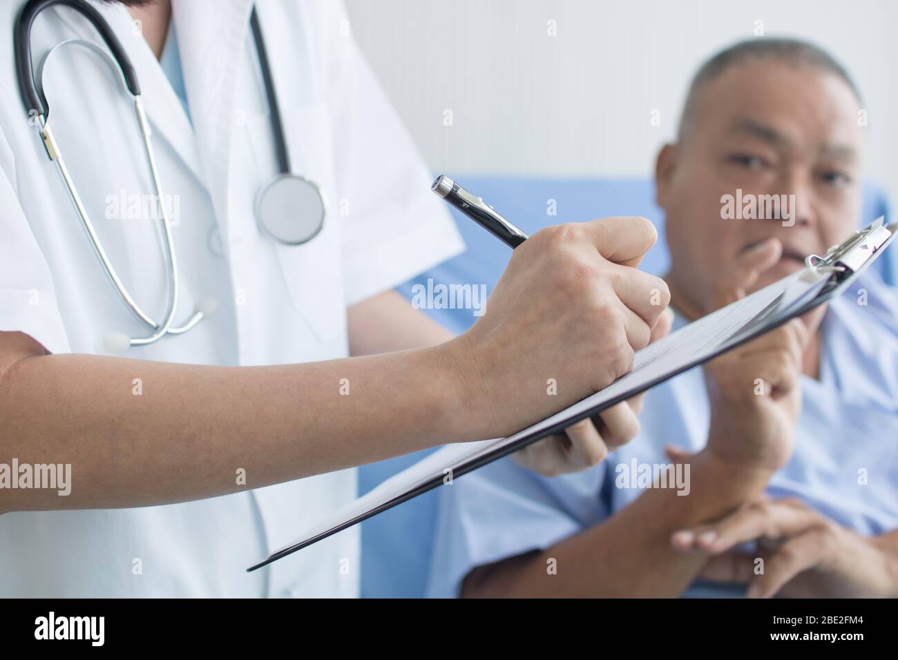 doctor asking and writing on sheet, patient interview and history ...