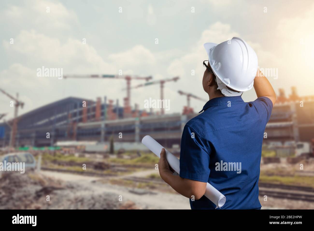 engineer holding blueprint with construction building background ...